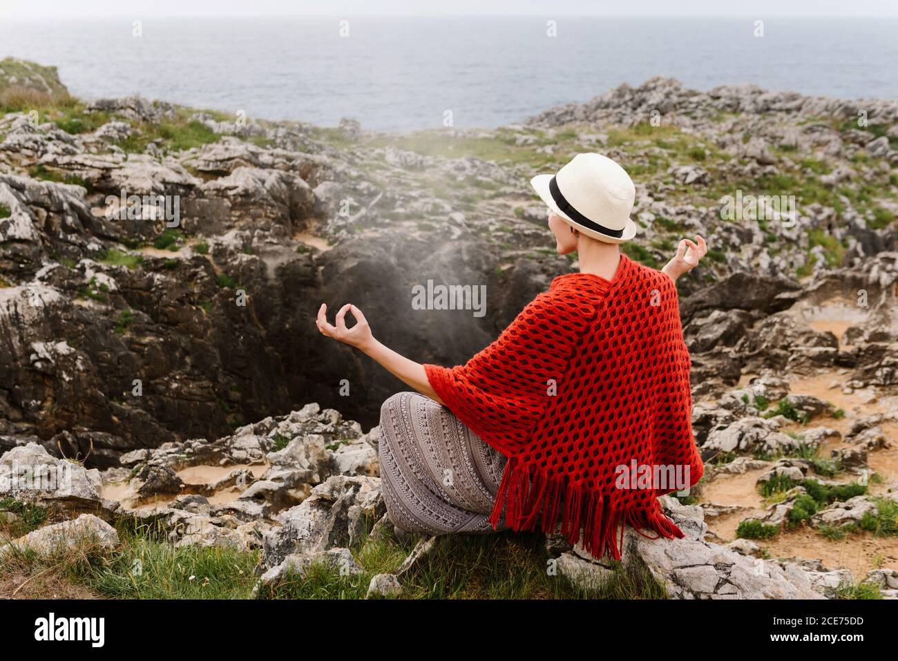 Back view of unrecognizable female traveler in stylish knitwear and hat ...