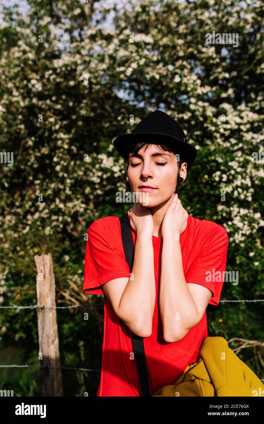 Serene female in trendy clothes relaxing in rural area and standing ...