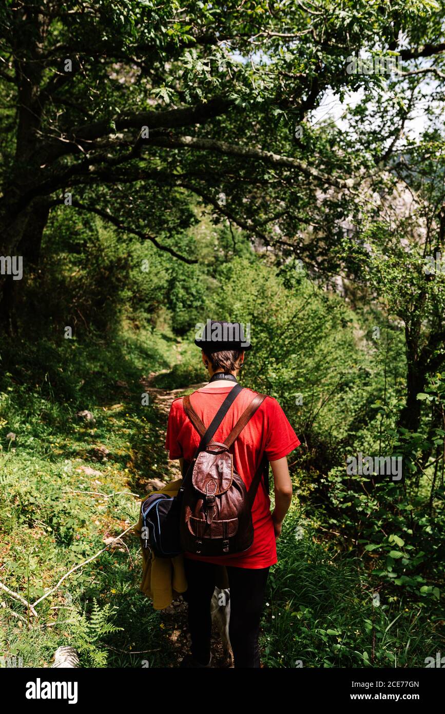 Full body of active bearded male in black cap jumping rope while ...