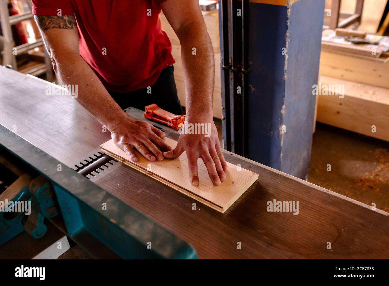 High angle of anonymous male woodworker standing at workbench with ...