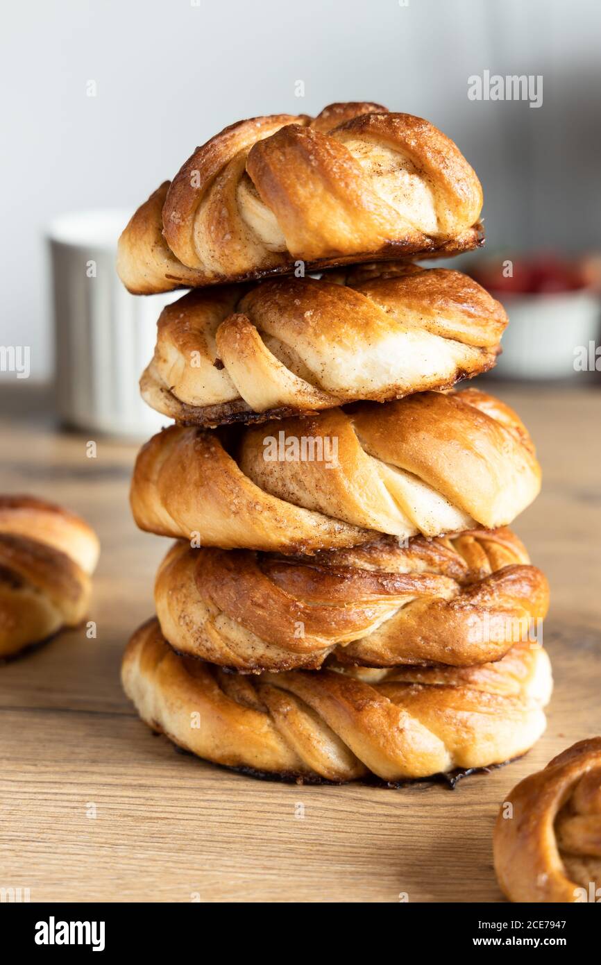 Stack of tasty cinnamon rolls placed on wooden table with cup of coffee ...