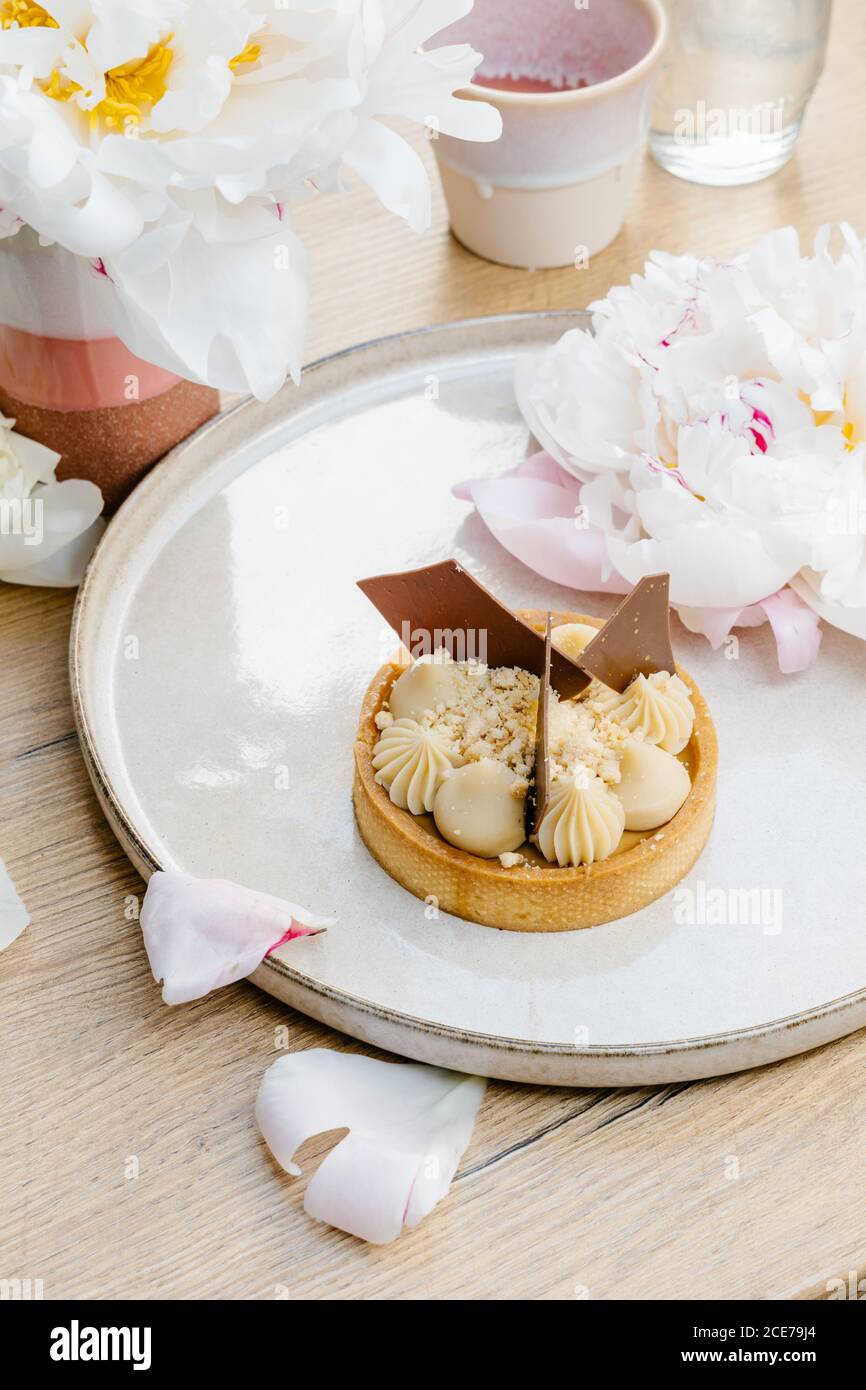 High angle of palatable caramel tart garnished with white and milk ...