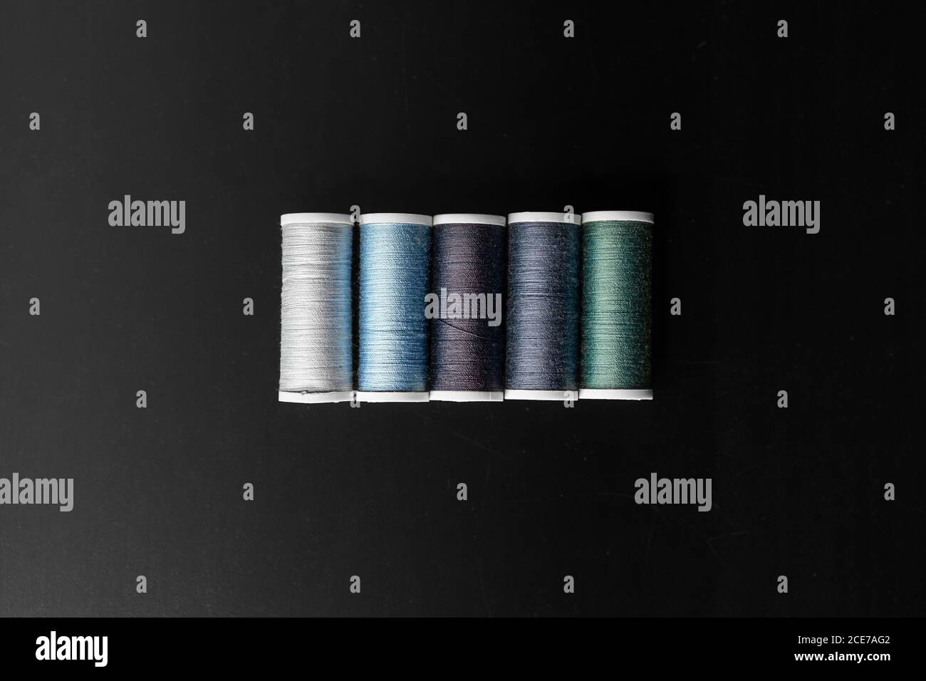 Kit of colorful reels of threads in atelier on black background Stock ...