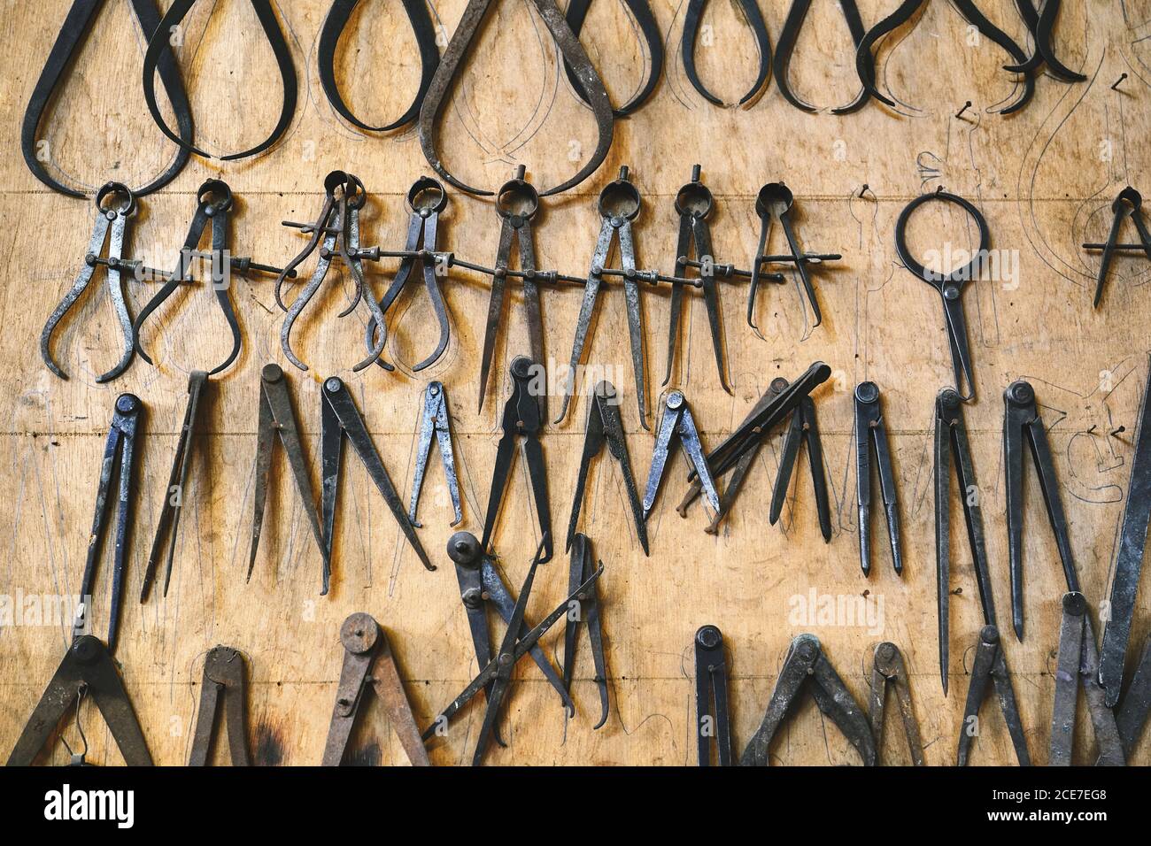 Set of various metal jewelry instruments on wooden wall representing ...