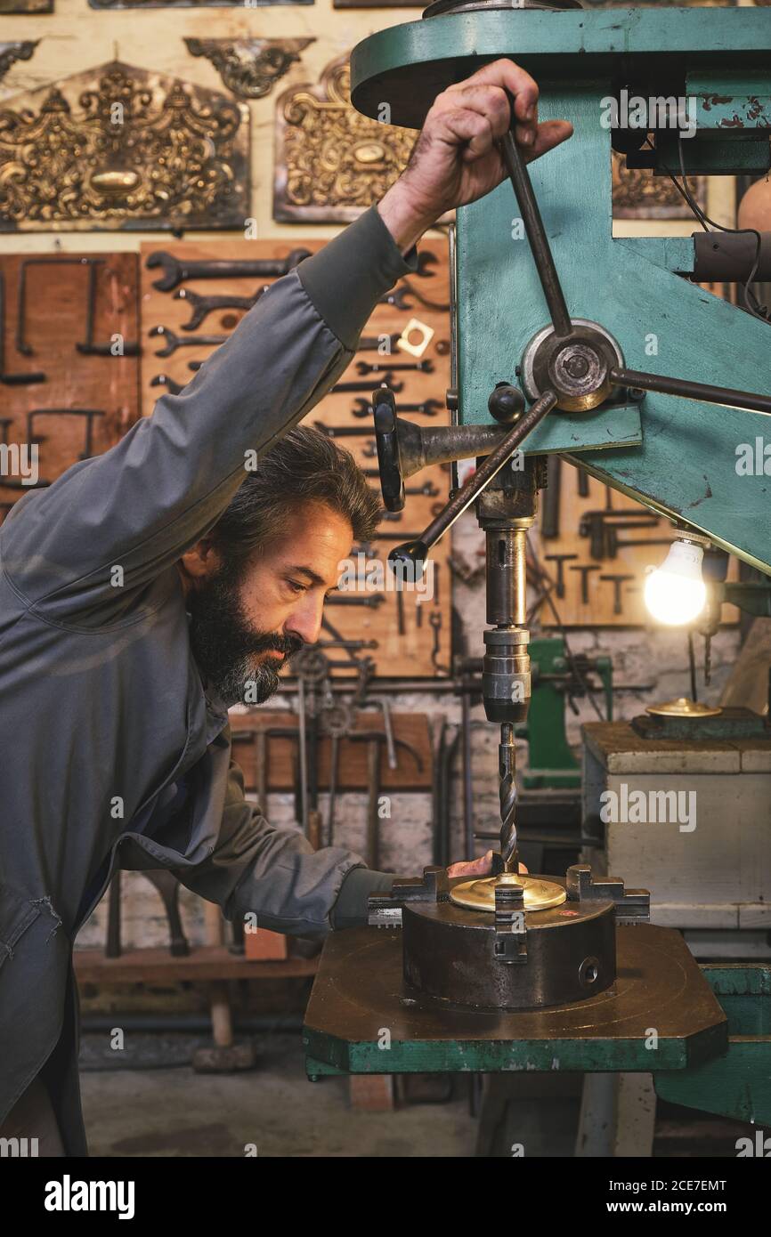 Side view of concentrated middle aged serious craftsman in uniform ...