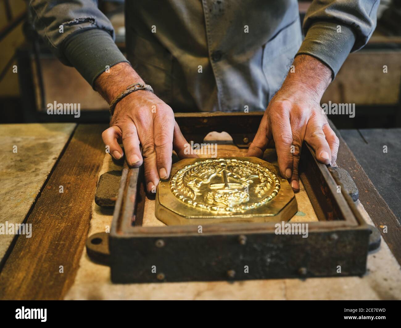 Crop unrecognizable goldsmith placing metal pattern into molding box ...