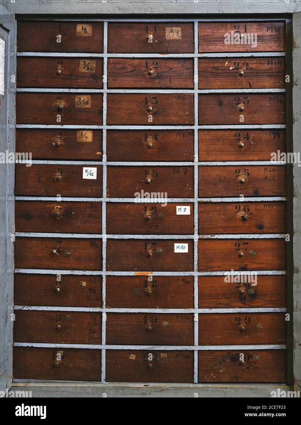 Archive representing identical dark brown wooden drawers with numbers ...