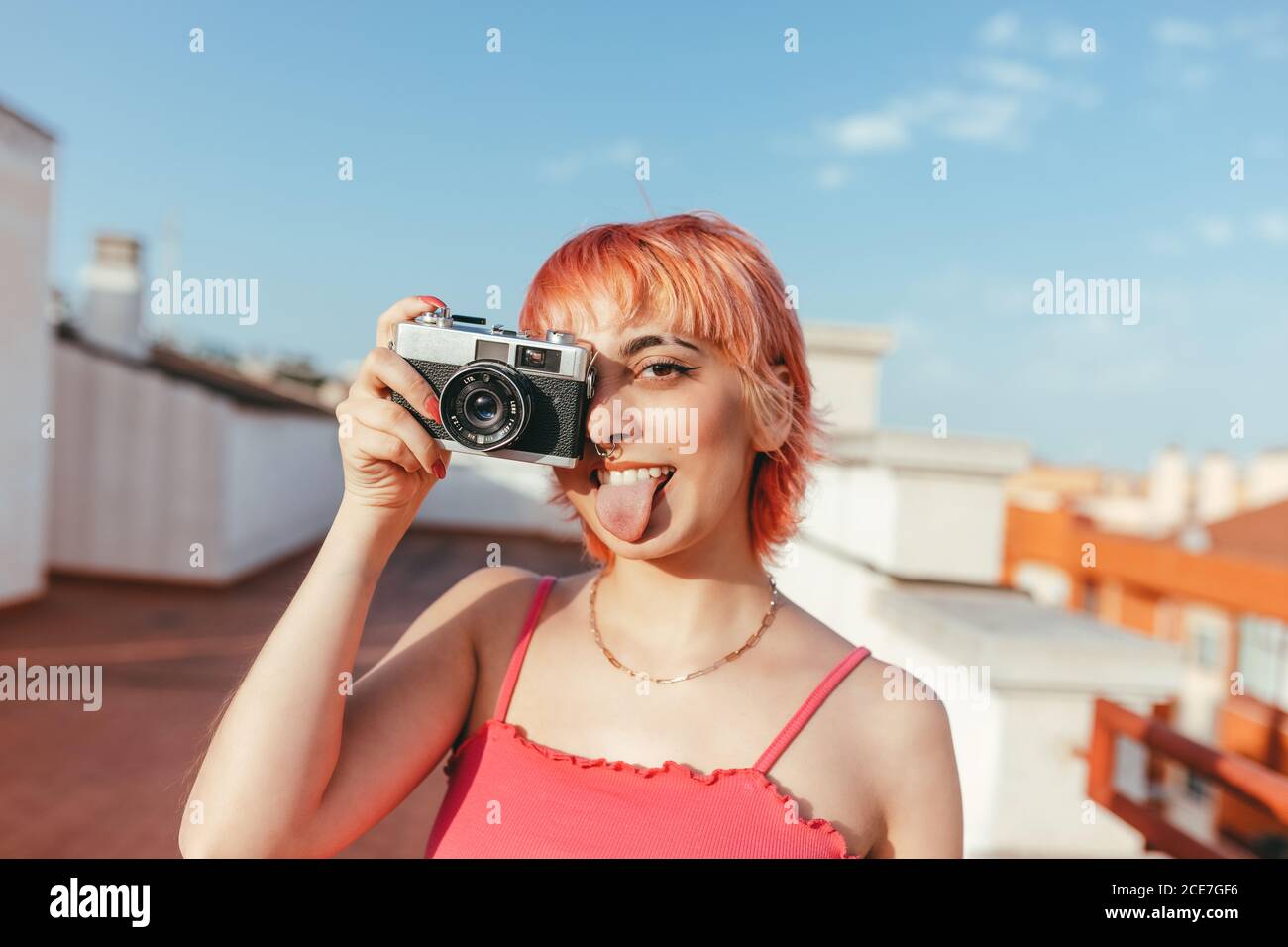 Naughty female millennial with piercing and pink hair taking pictures ...