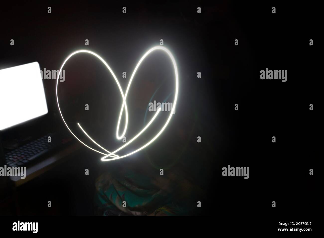 Light Forming a Love Symbol in Front of a Computer in a Dark Place ...
