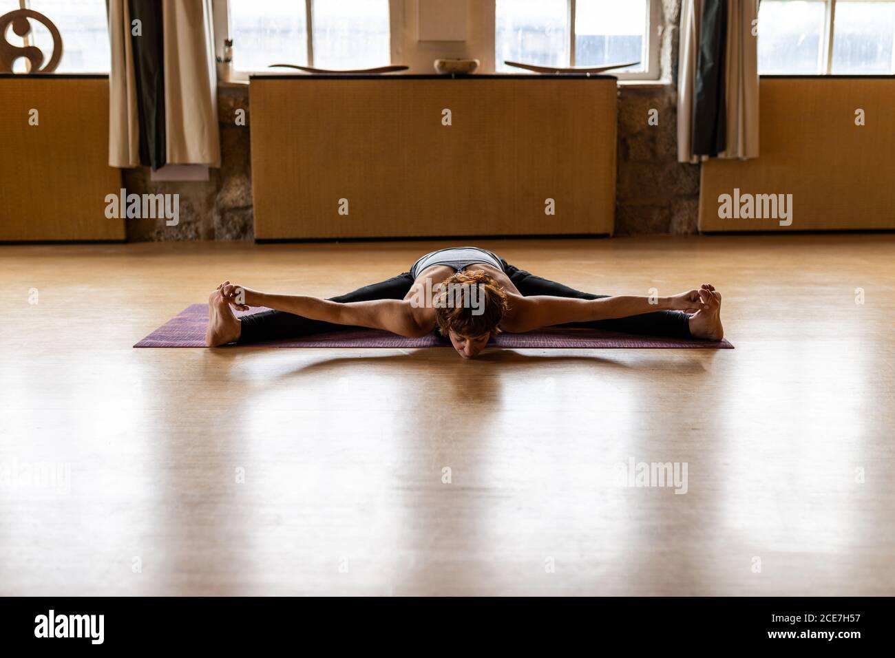 Full body of focused female yogi in sportswear performing Seated Wide ...