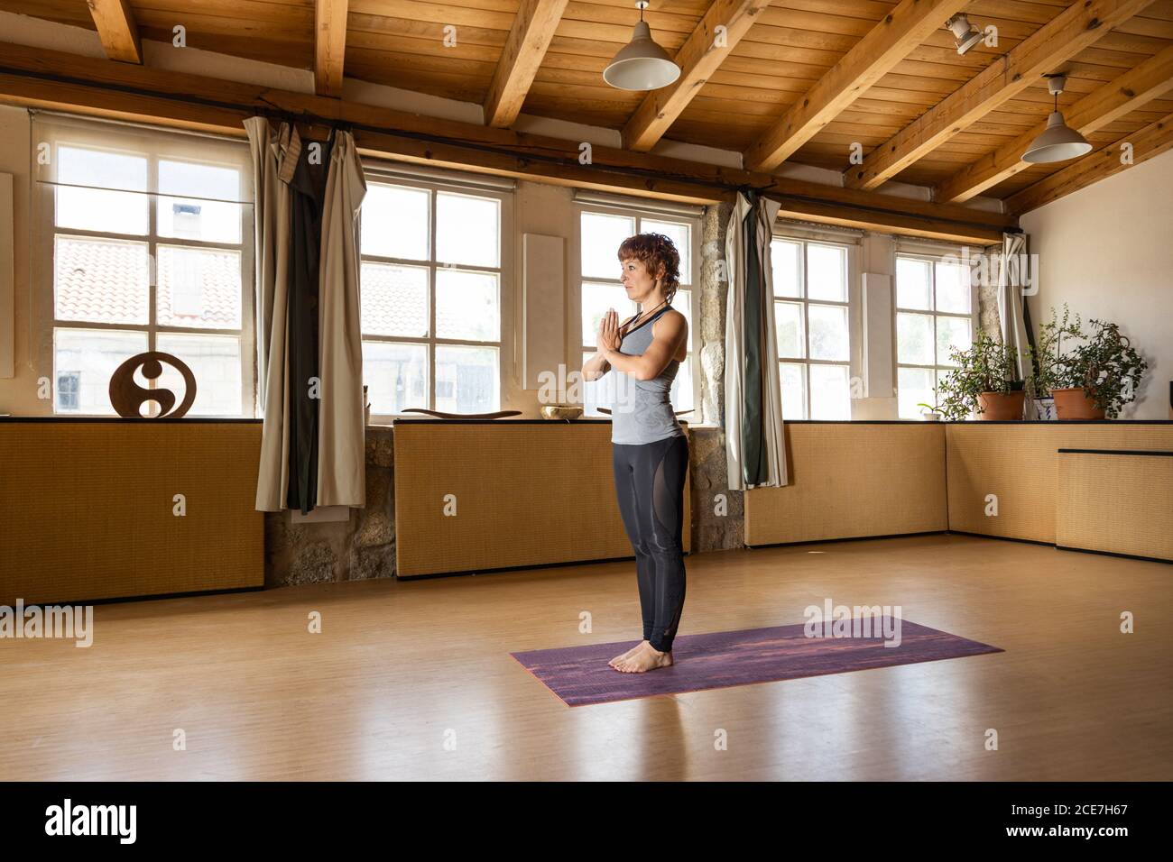 Full body side view of female standing in Mountain pose with namaste ...