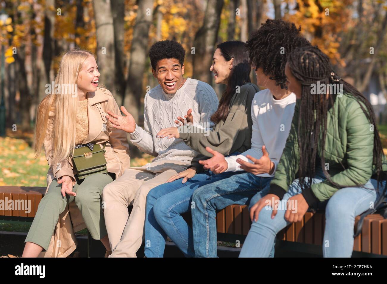 Black cheerful guy telling friends funny story Stock Photo - Alamy