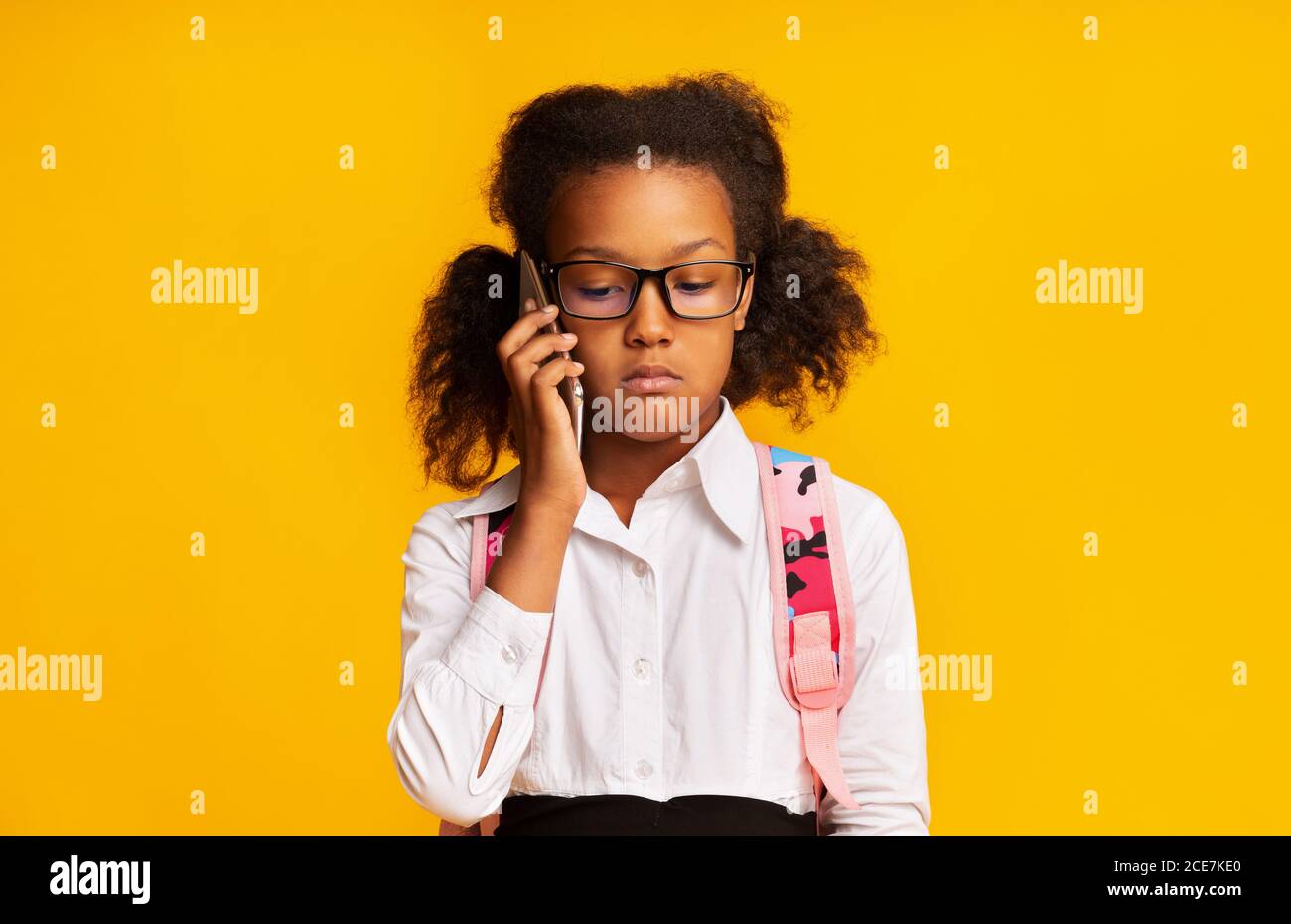 Sulky Black Schoolgirl Talking On Phone With Parents In Studio Stock ...