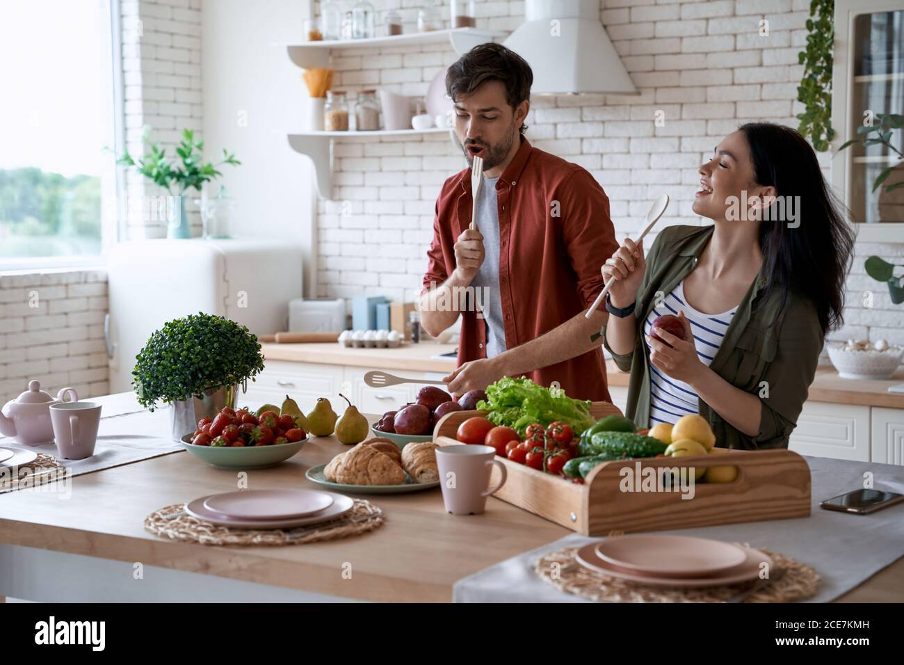 Young happy family couple dancing, singing and having fun while ...