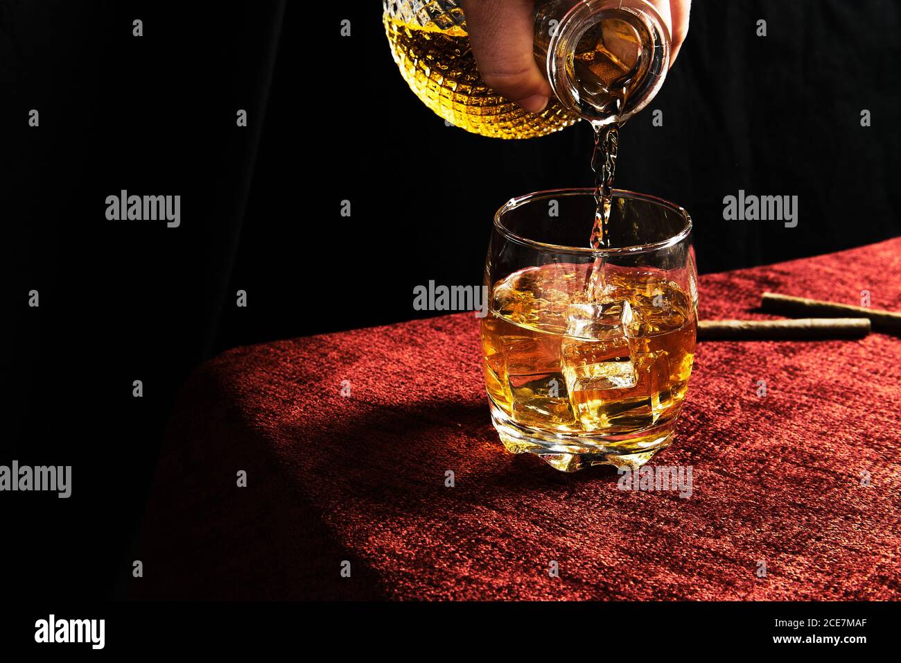 anonymous person serving whiskey in a glass Stock Photo - Alamy