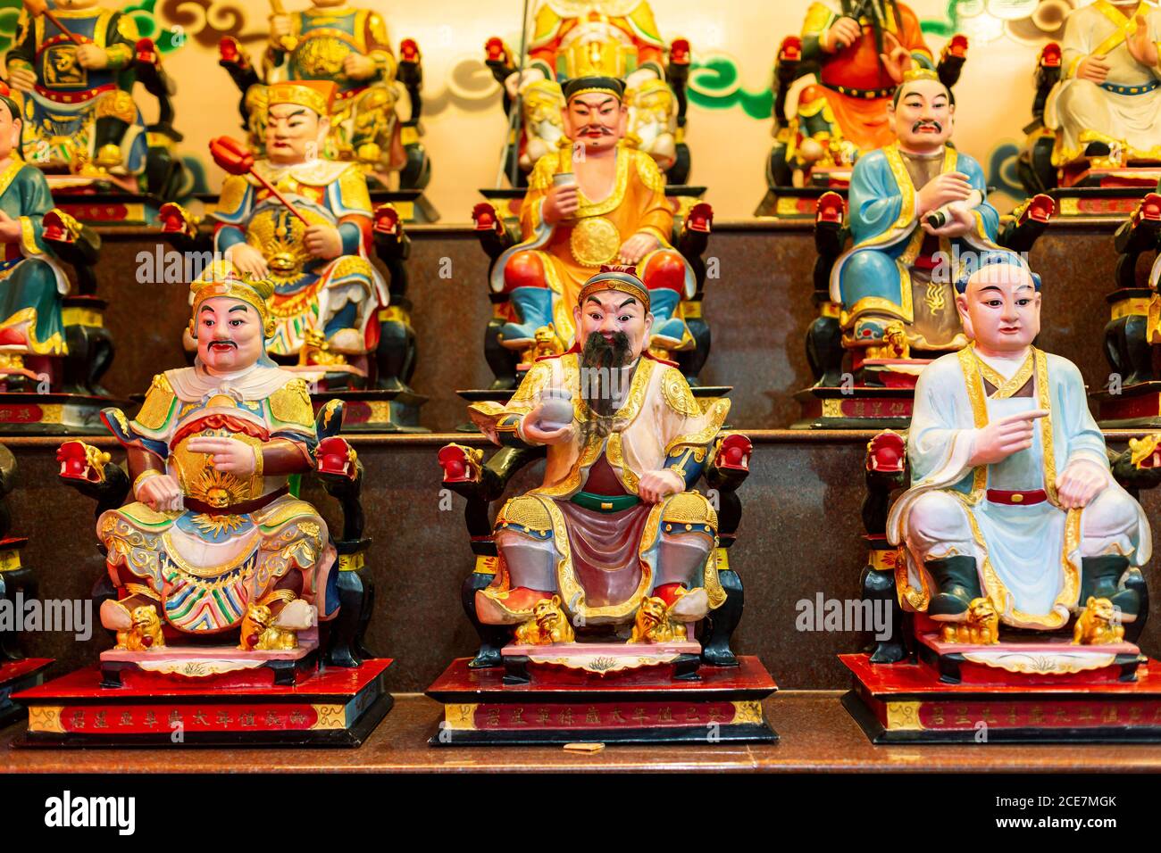Collection of colorful Chinese statues placed on stone stairs in temple ...
