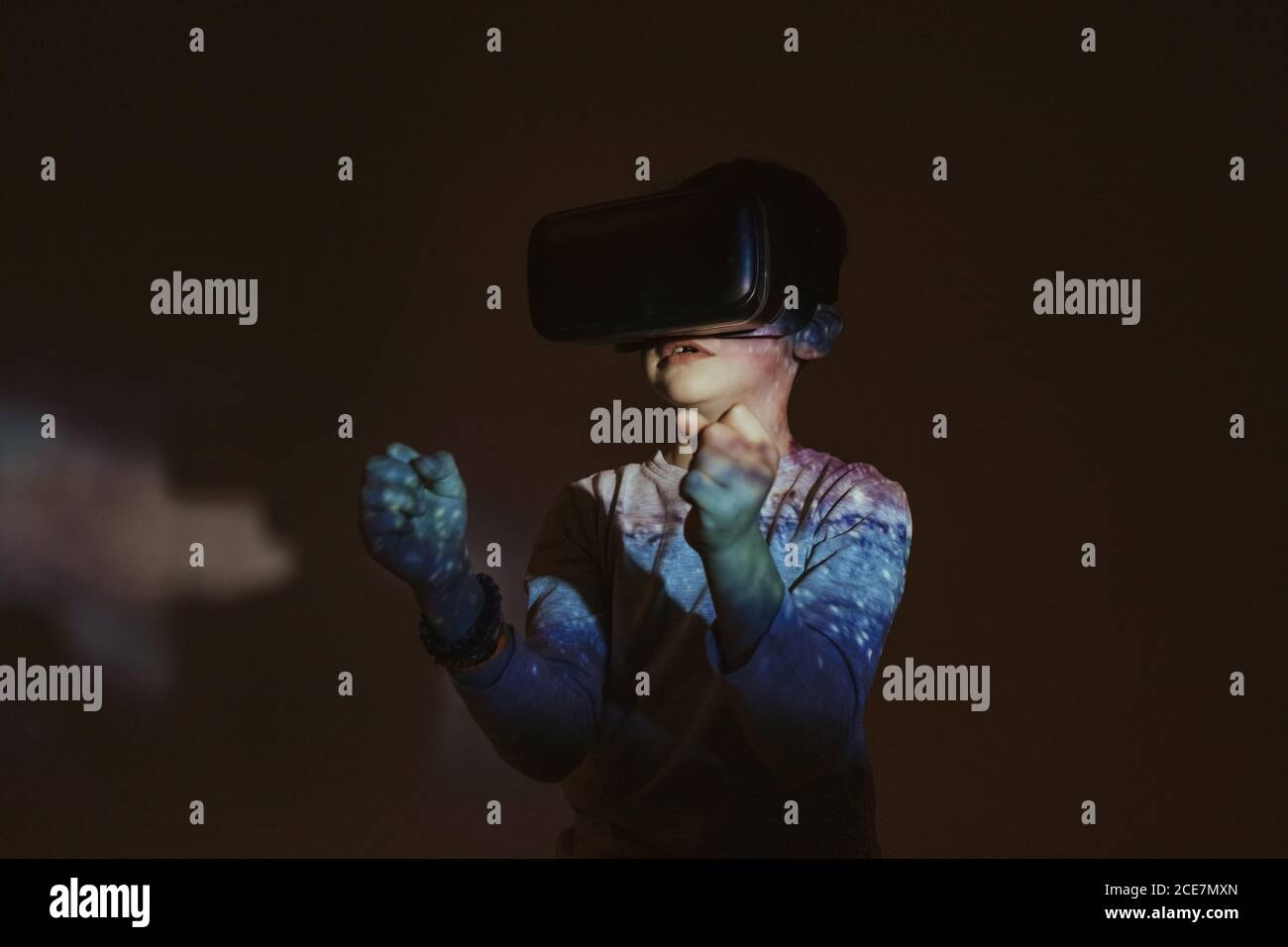 Cute boy wearing VR glasses and exploring virtual reality with excited ...
