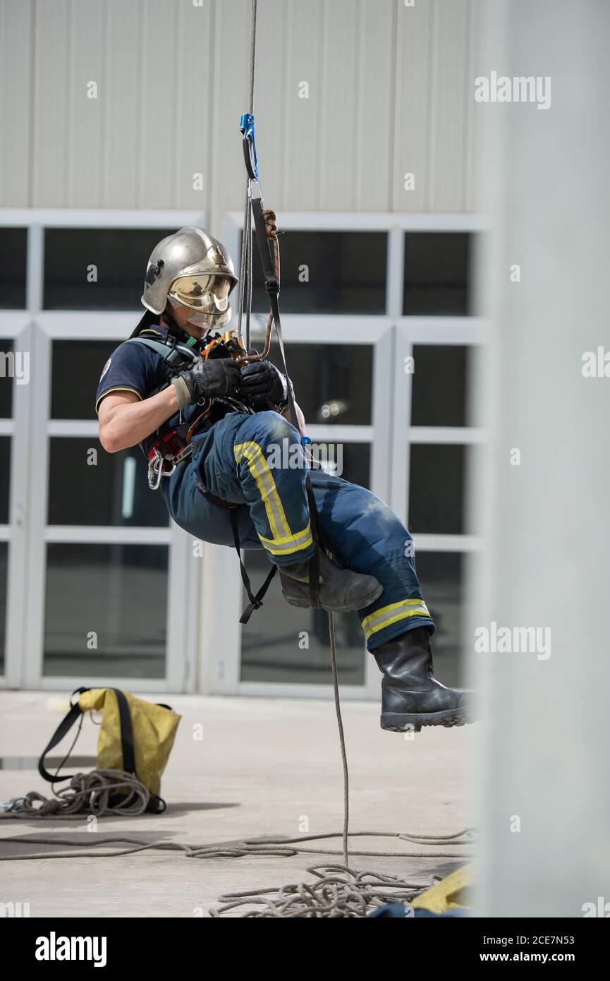 Side view of strong firefighter in protective equipment during training ...