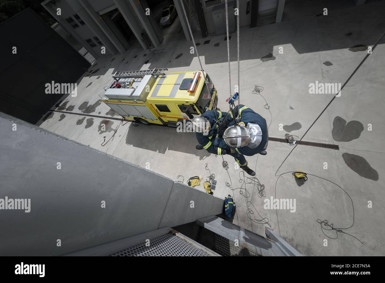 From above of firefighters in protective equipment climbing ropes near ...