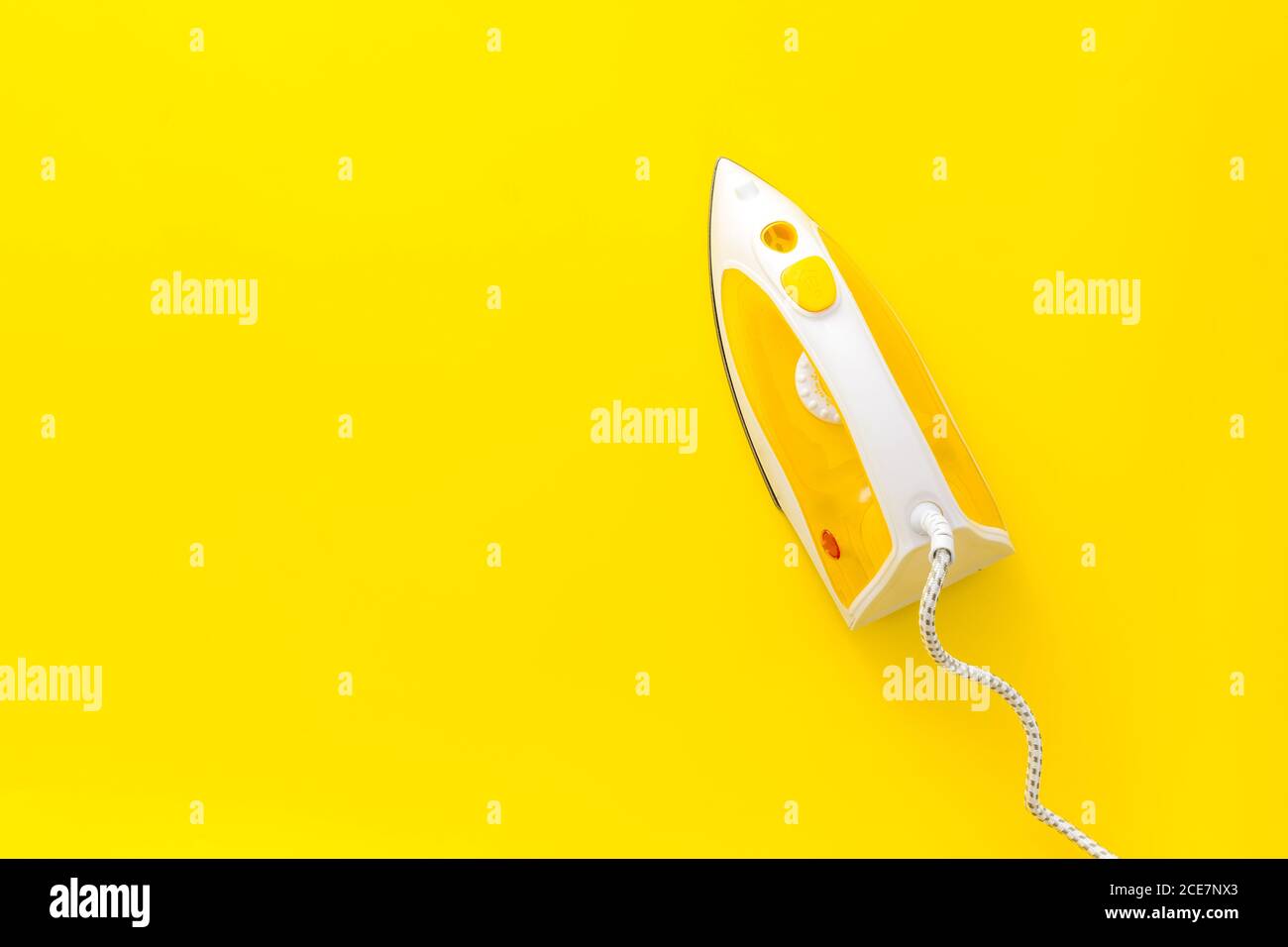 Top view of yellow iron on ironin board Stock Photo - Alamy