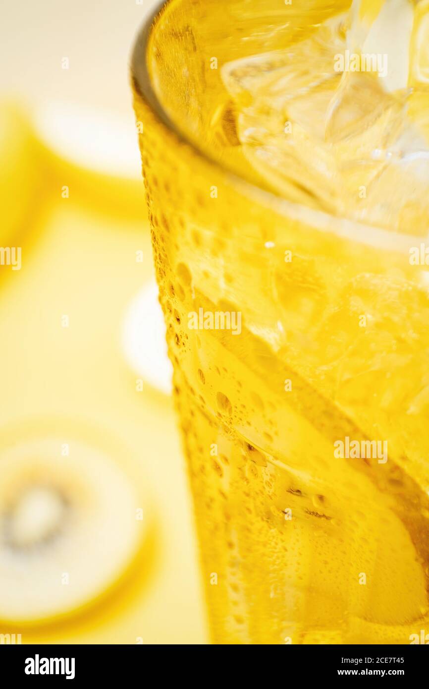 From above crop detail of glass of fresh beverage with lemons and kiwi ...