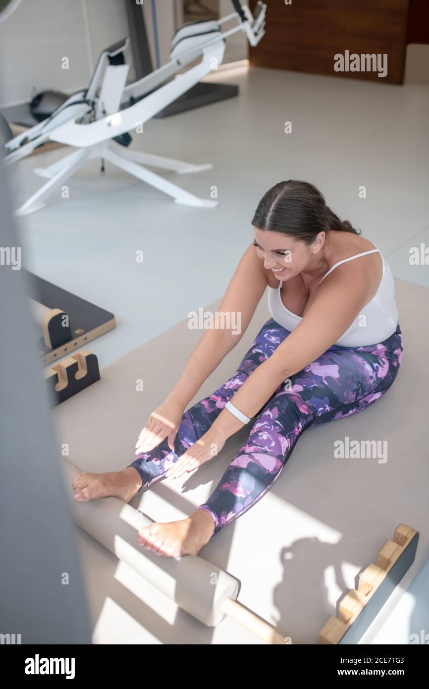 Brunette young plus size woman stretching on the floor Stock Photo - Alamy