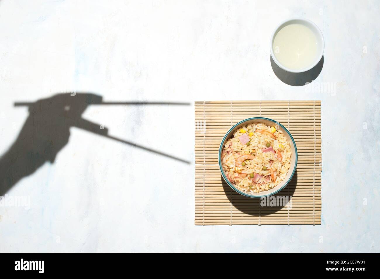 Top view of shadow of person with chopsticks and bowl with freshly ...