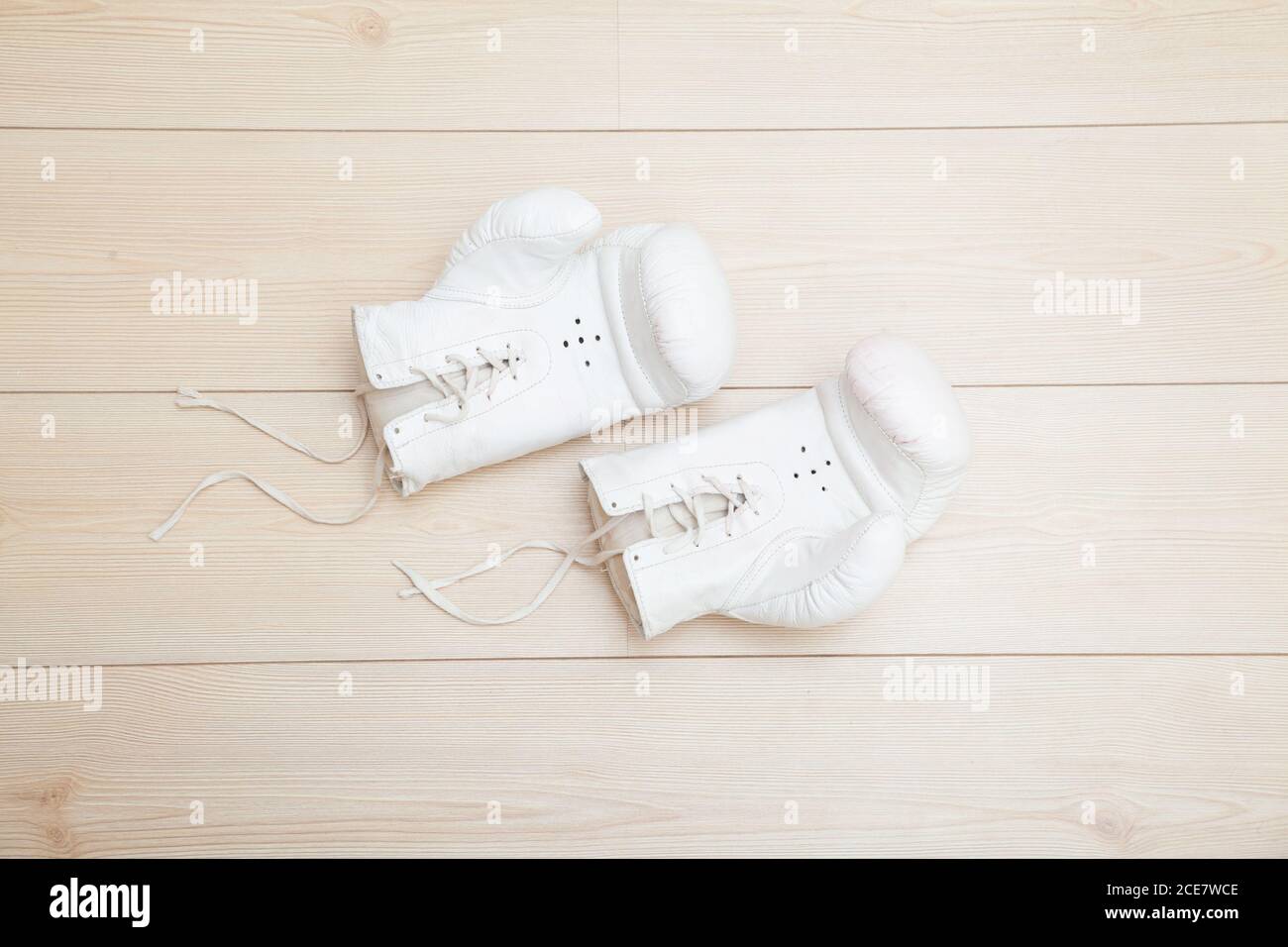 White boxing gloves on wooden floor Stock Photo - Alamy