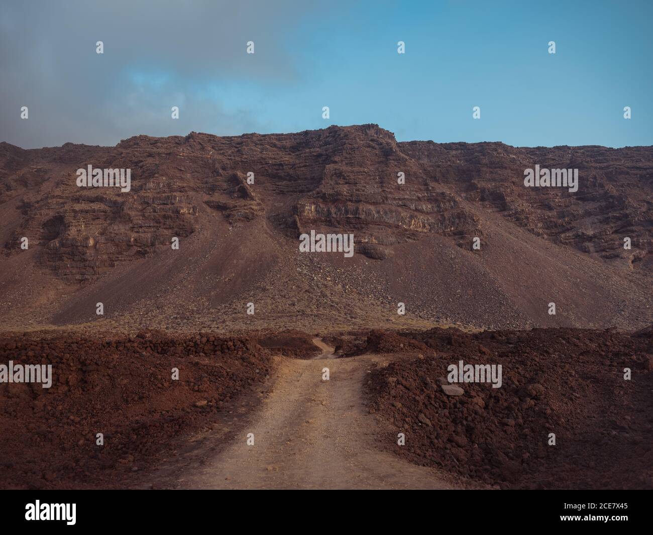 Narrow empty pathway between shabby terrain with small stones leading ...