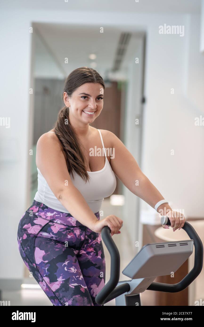 Woman doing cardiovascular exercises using an exercise bike Stock Photo ...