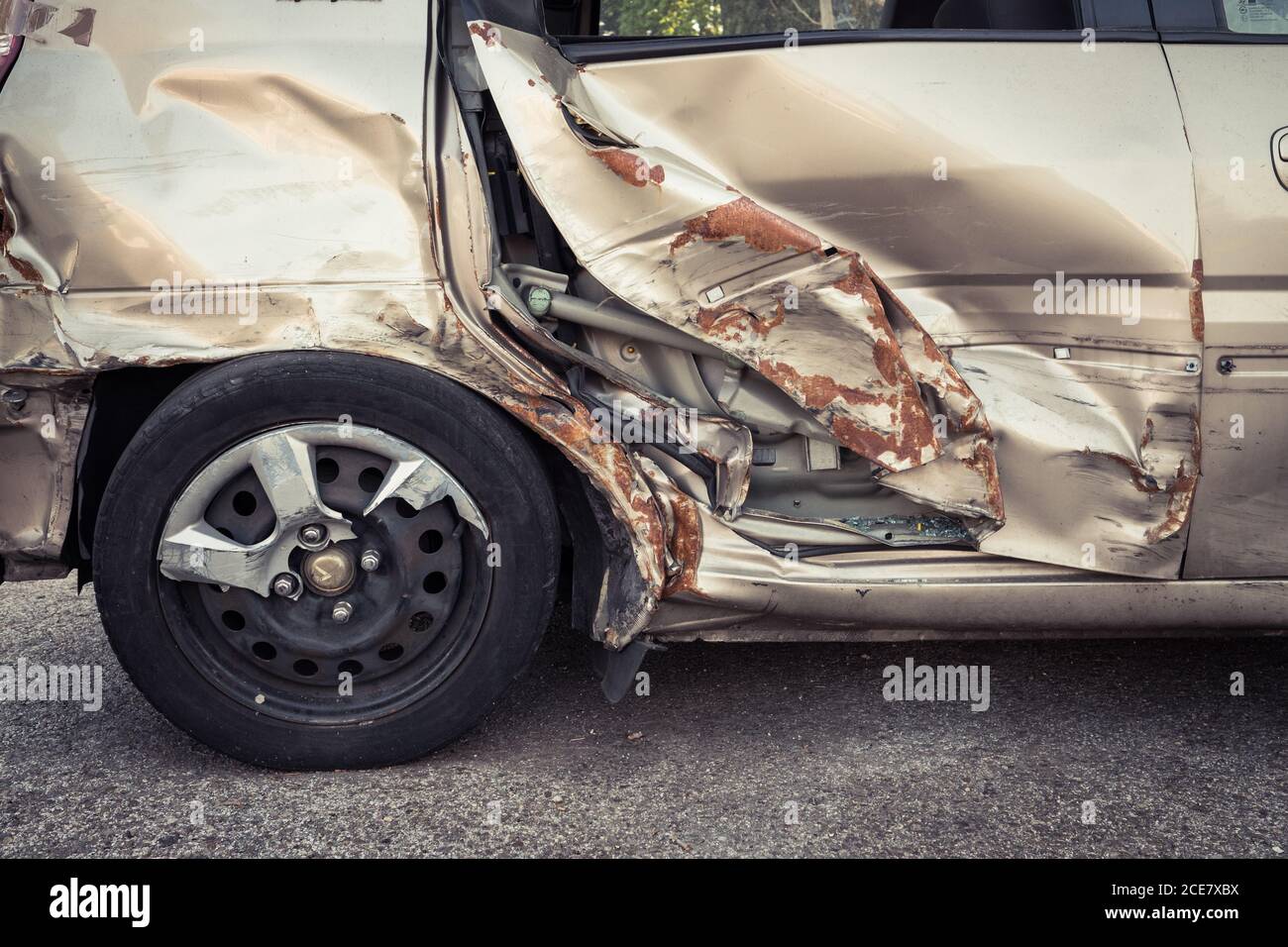 Modern car with dent on back door with rusty surface and partially ...
