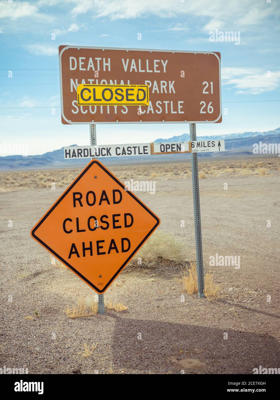 Temporary road sign with bright ROAD CLOSED AHEAD title and sticker ...