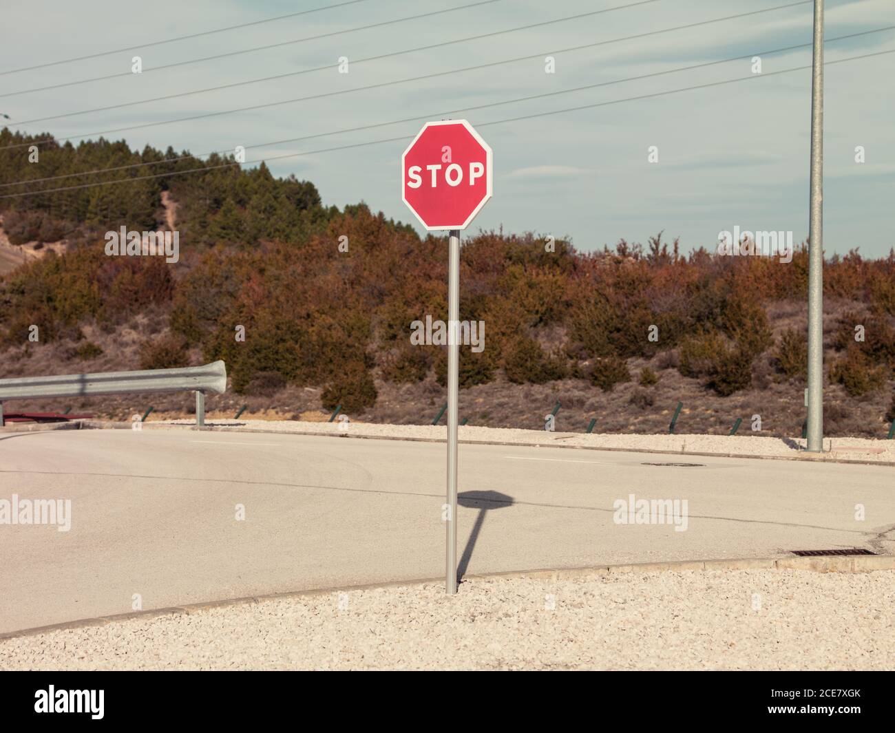 Round red prohibitory road sign with word stop on empty asphalt roadway ...