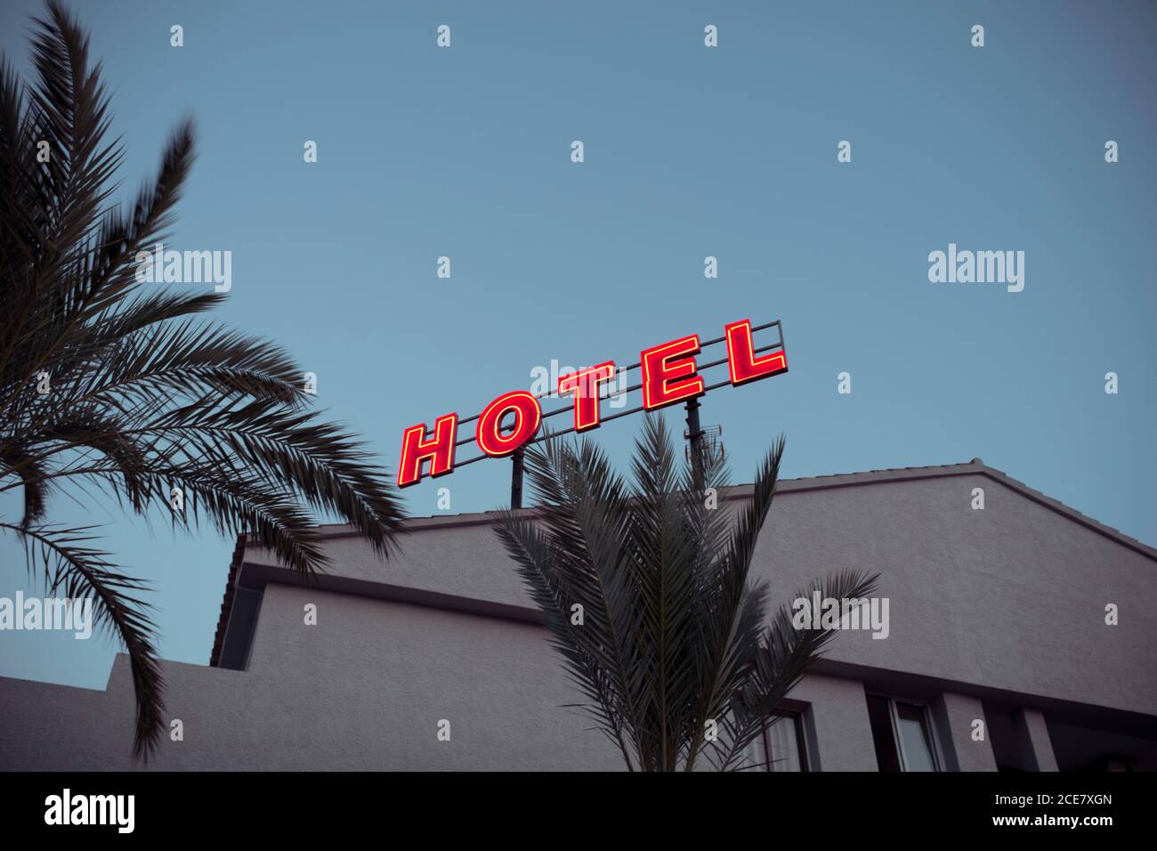 Low angle of illuminated hotel word made with big red neon letters and ...