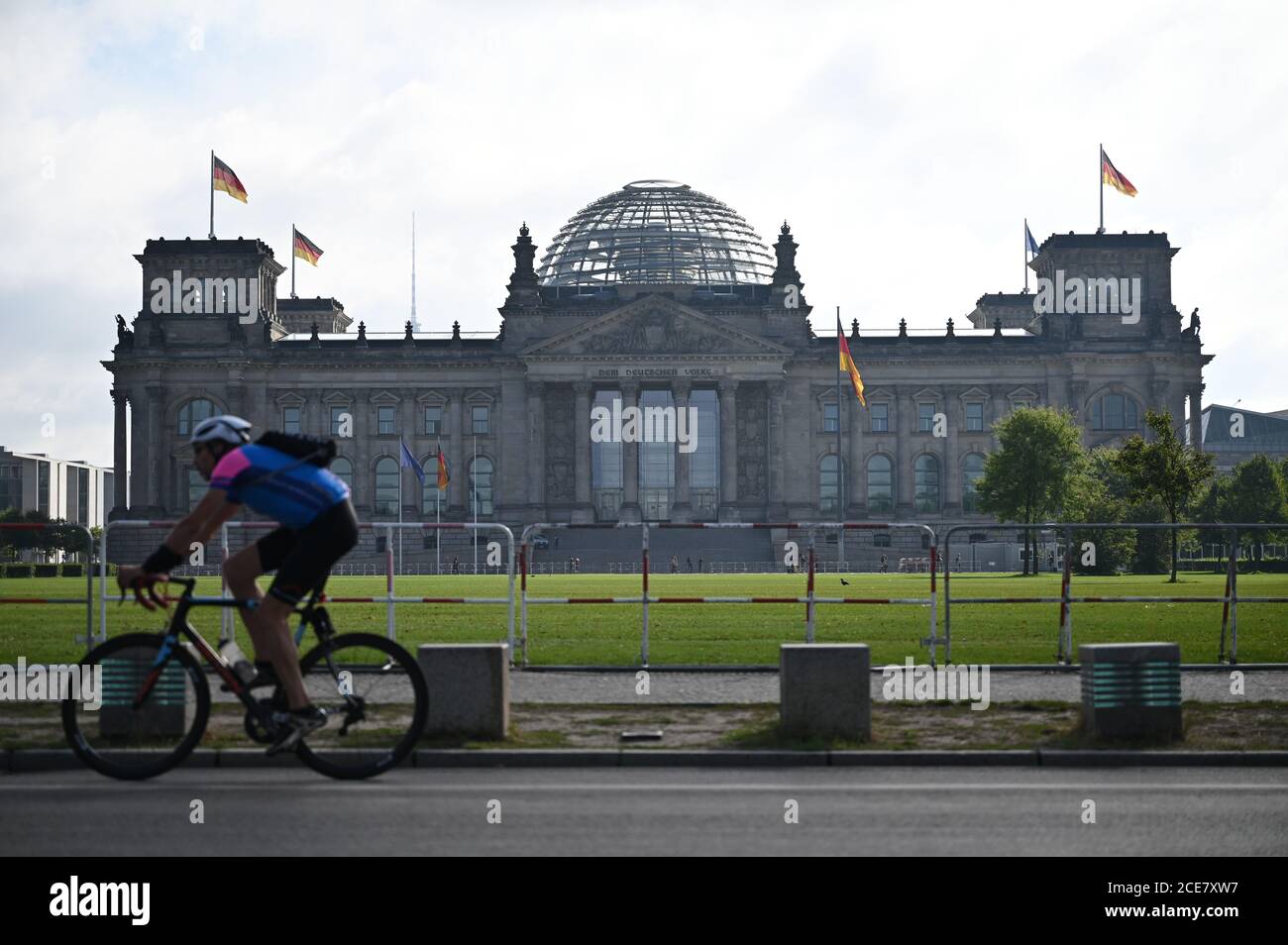 Berlin, Germany. 31st Aug, 2020. A cyclist rides along the Reichstag ...