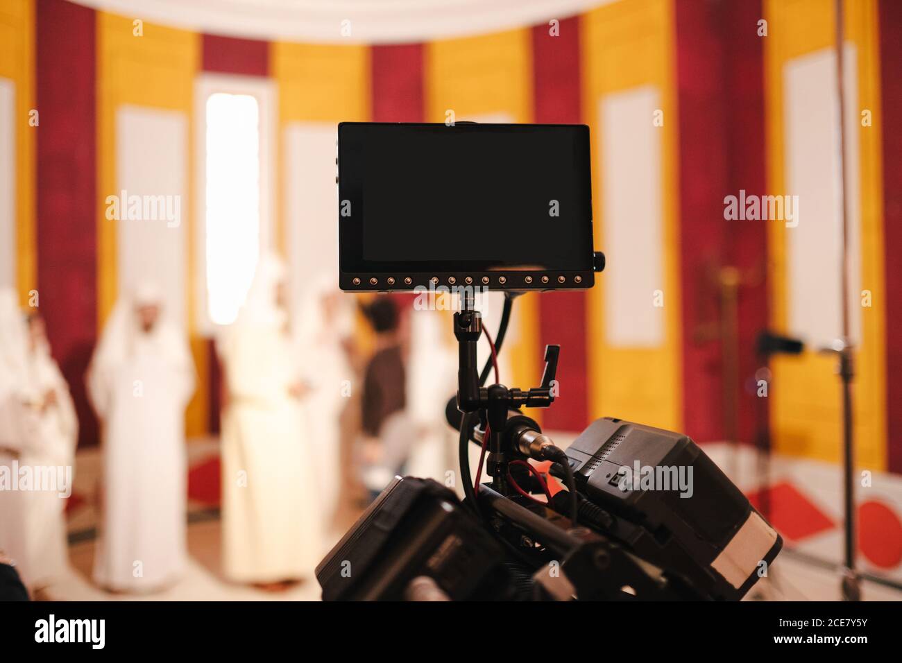 Professional video camera with black display placed against group of ...