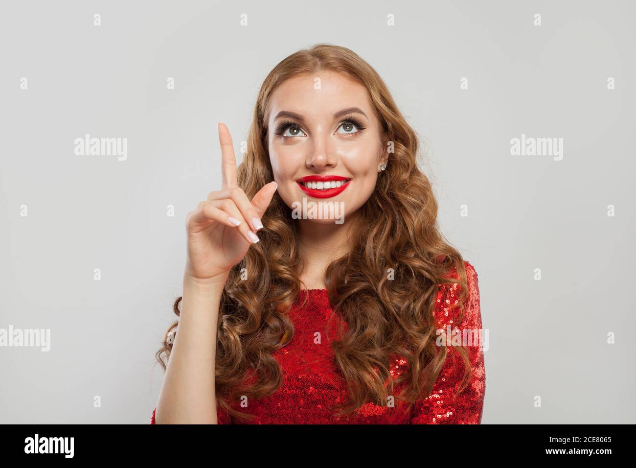 Beautiful young woman fashion model pointing up on white background ...