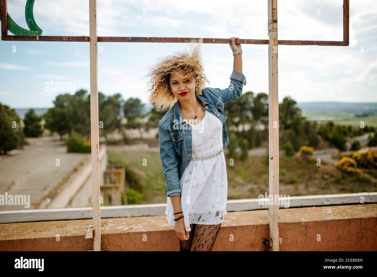Content African American female in fashionable wear standing near metal ...