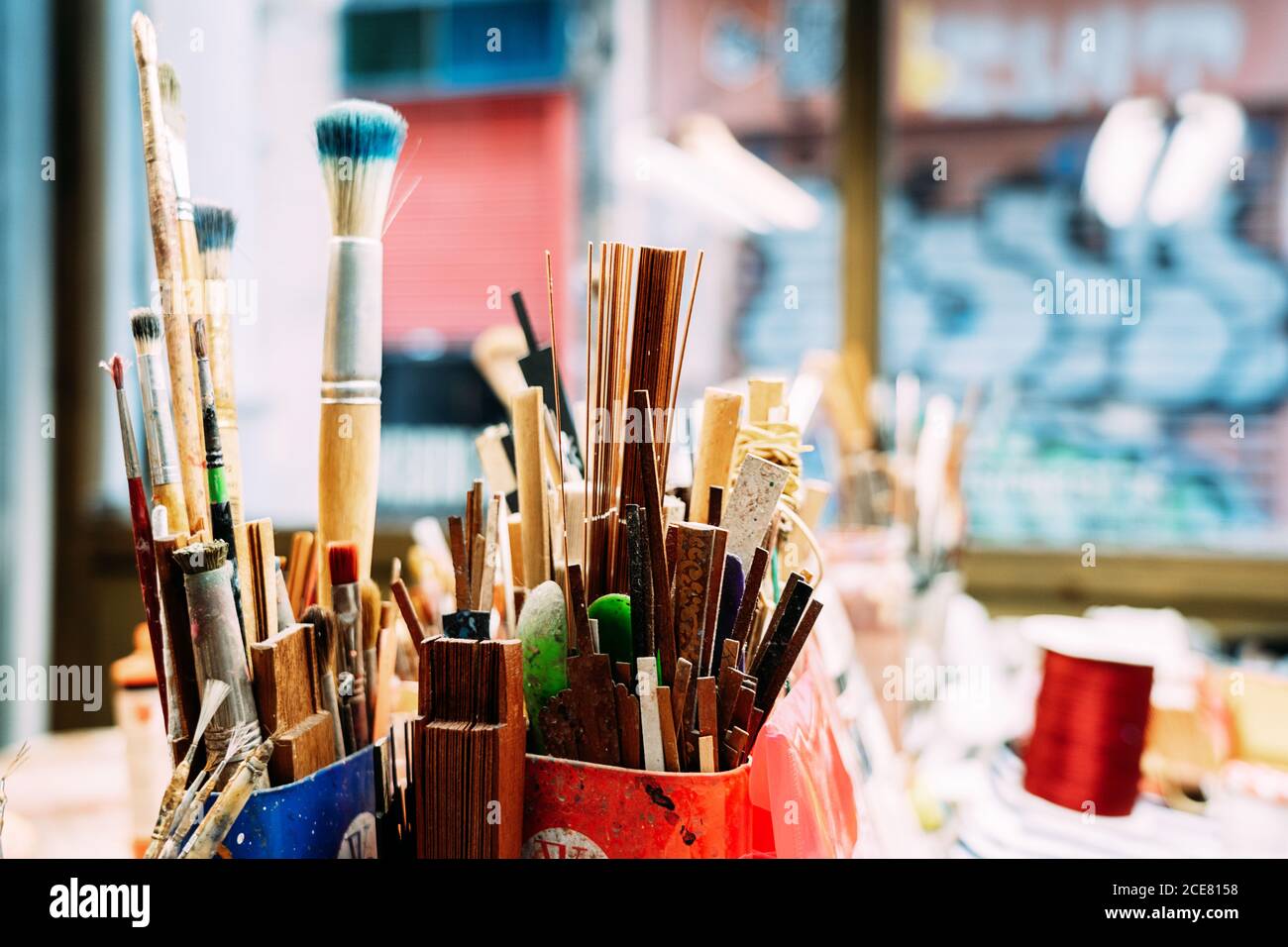 collection of paintbrushes of different sizes and bottles with paint in ...