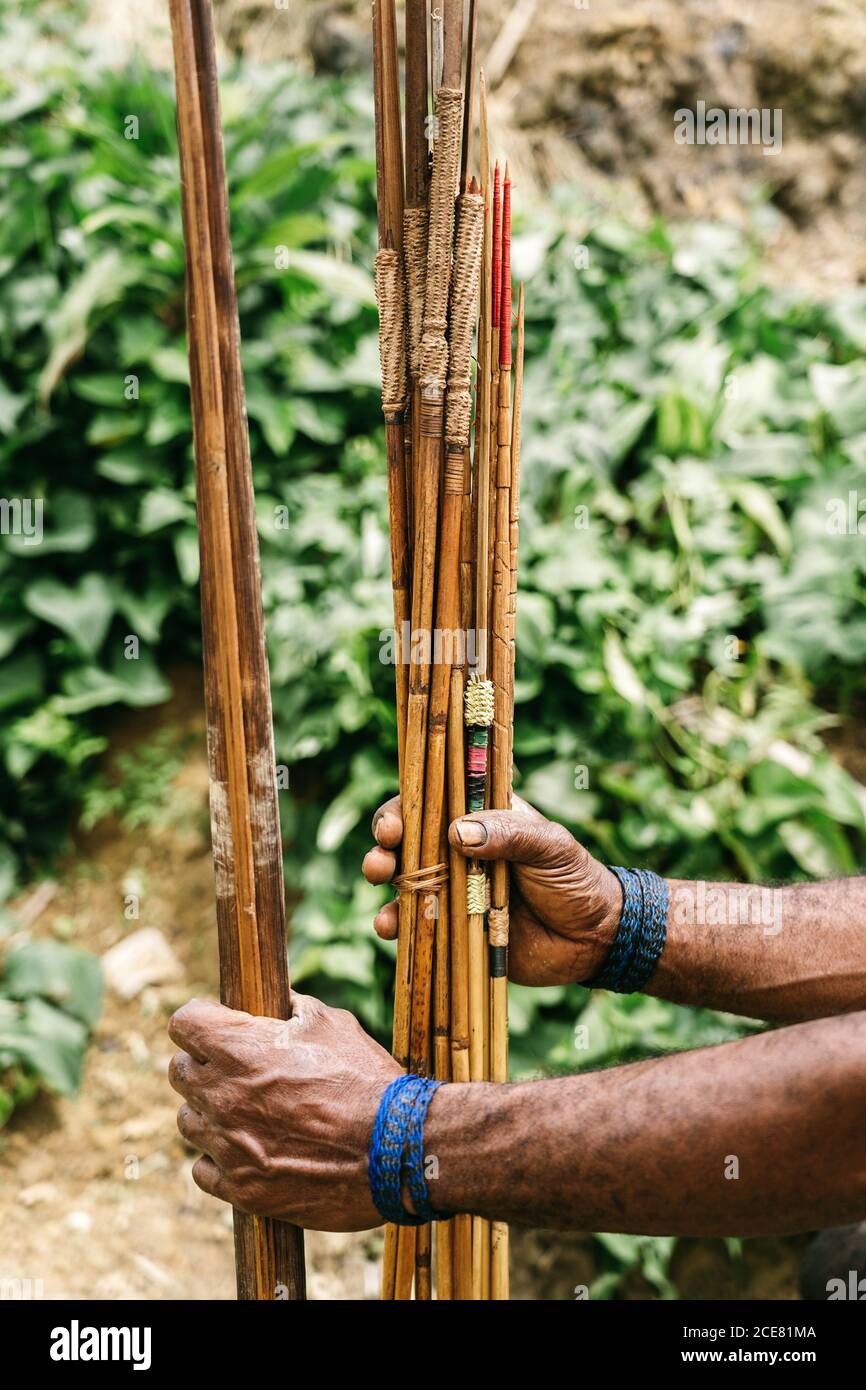 unrecognizable crop ethnic male from tribe standing with collection of ...