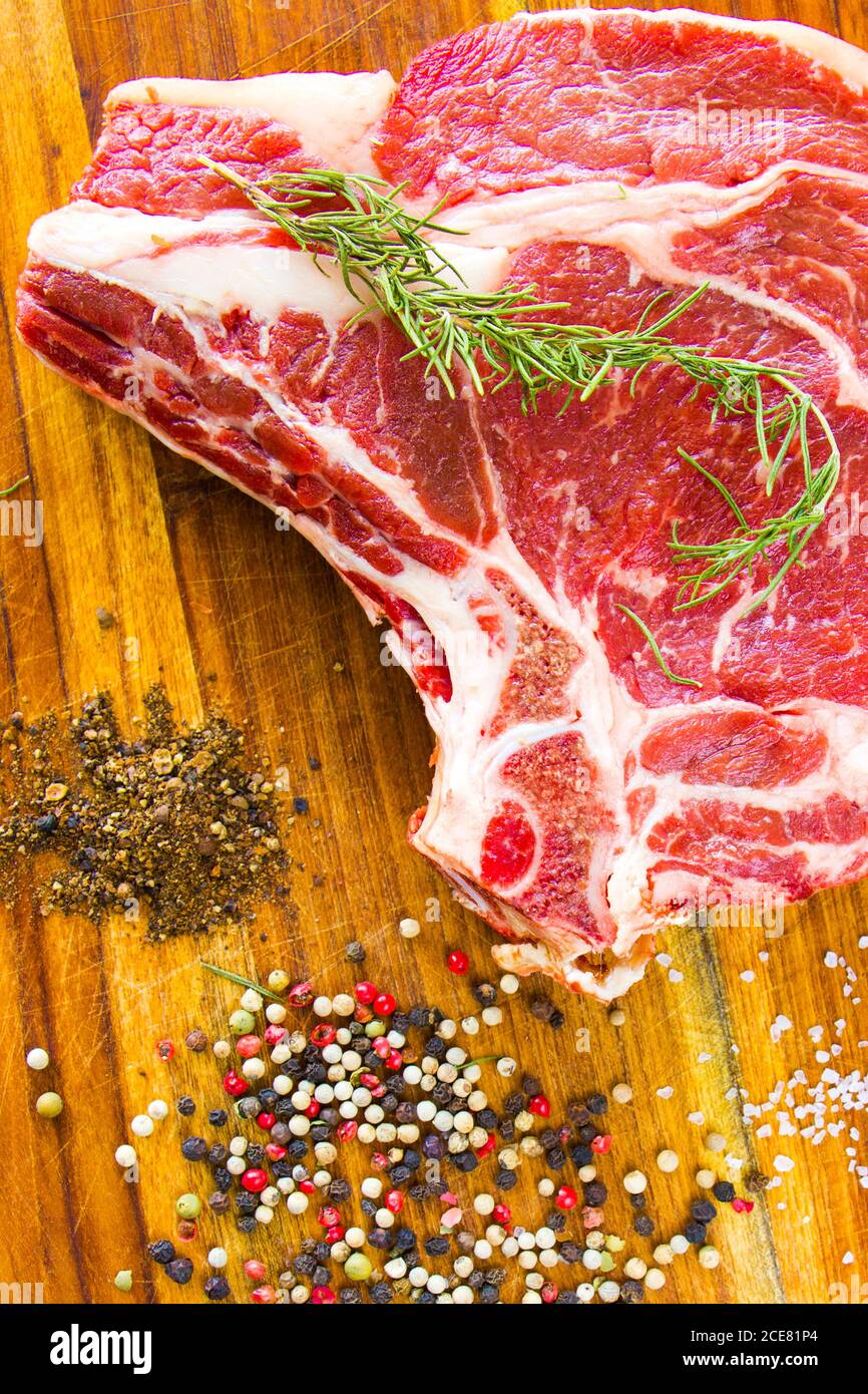 Raw beef meat on the table, spices and Rosemary, Rib eye steak ...