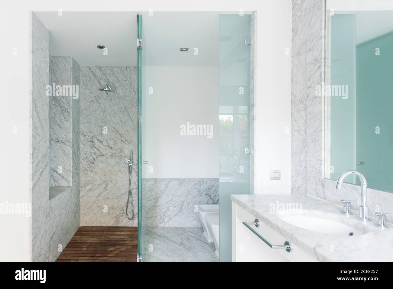 Creative design of clean bathroom with marble walls and oval sink under ...