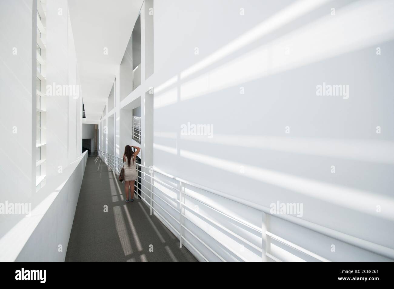 Back view of anonymous lady in formal wear touching head while standing ...