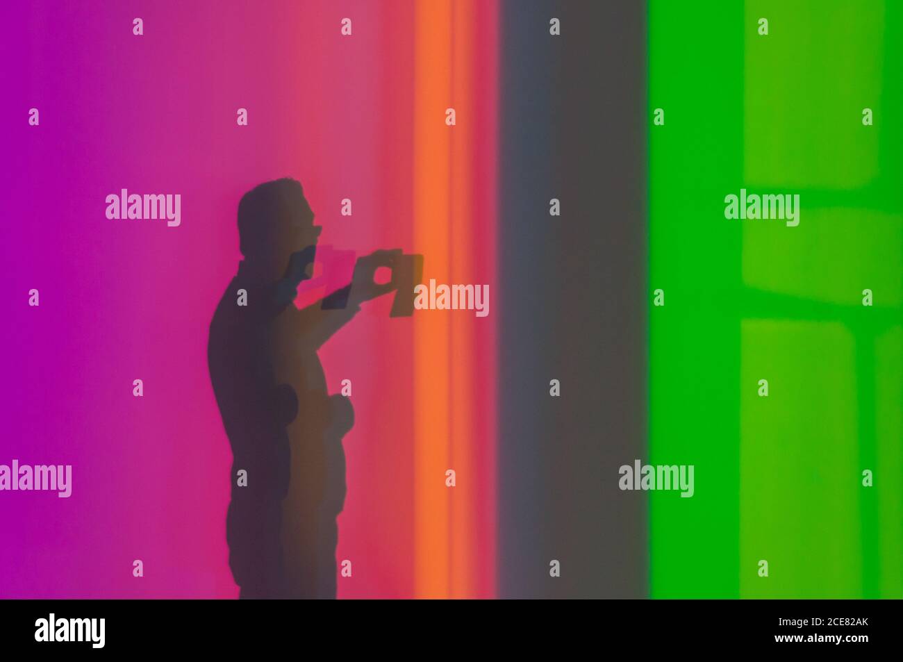 Shadow of anonymous male taking photo on smartphone while standing in ...