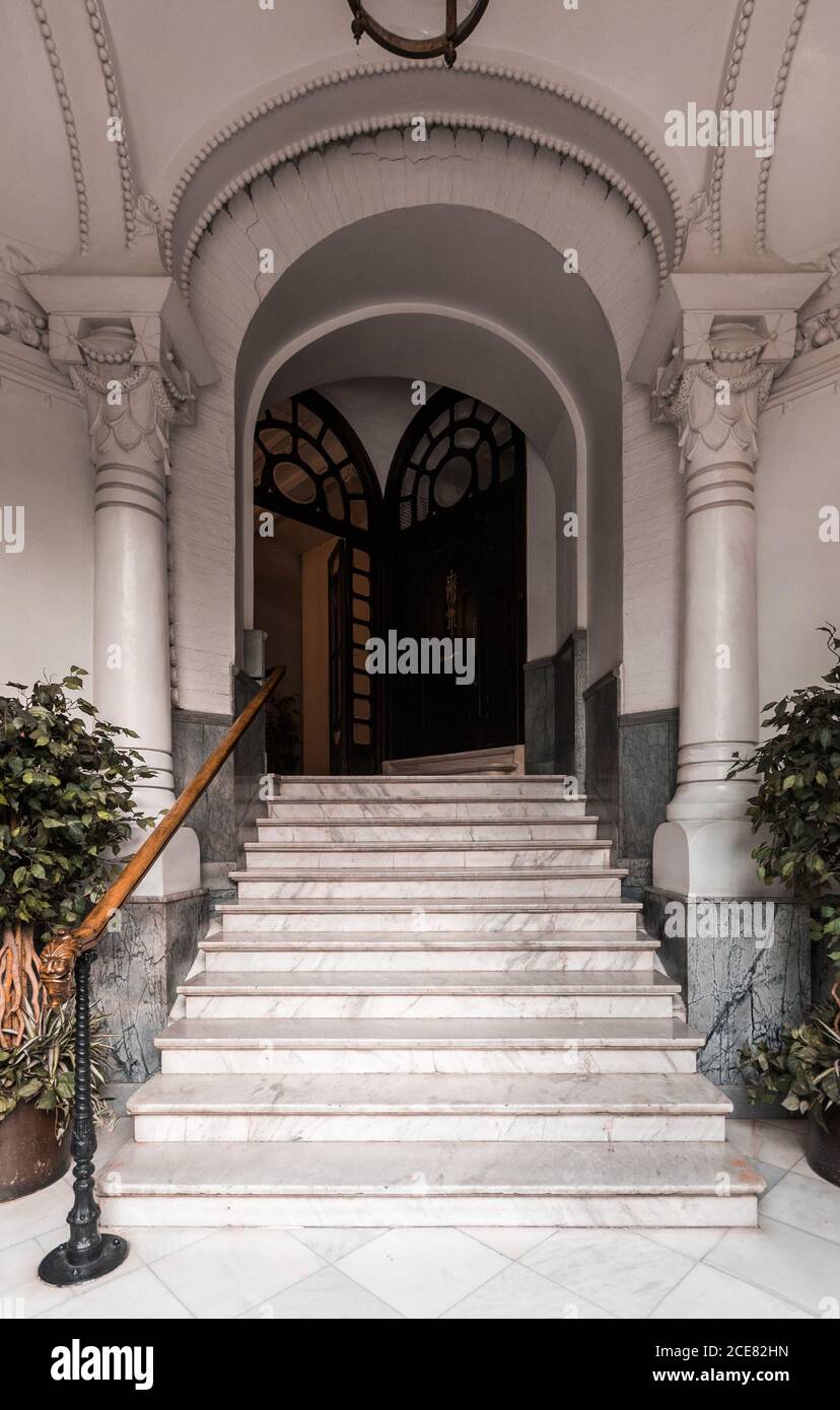 Large stair with wooden railing and classic columns with ornamental ...