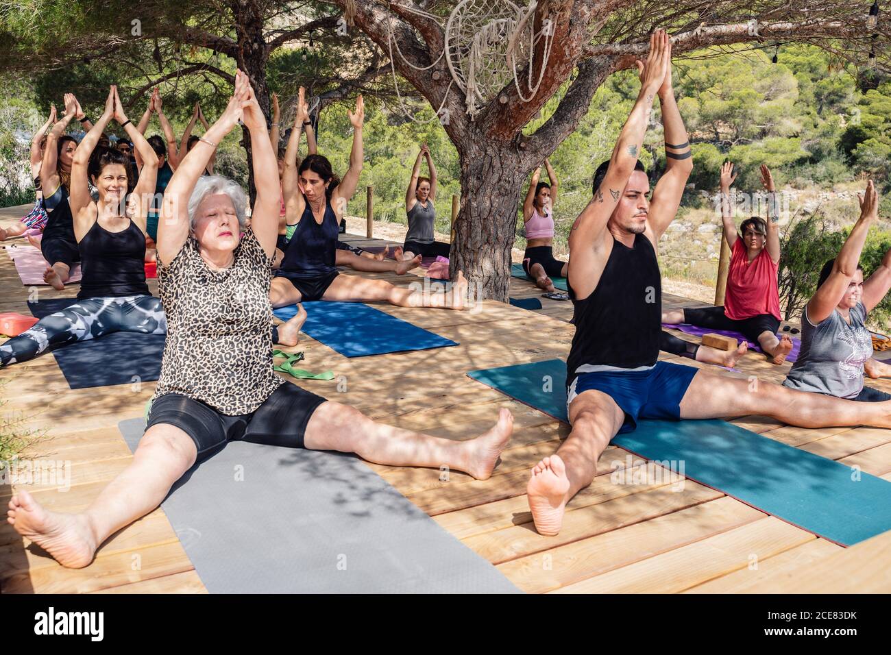 Group of diverse people of different ages doing Seated Wide Legged ...