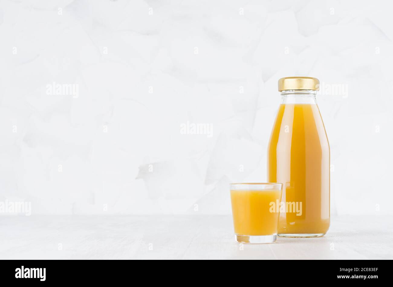 Fresh yellow mango juice in glass bottle mock up with wine glass, fruit ...