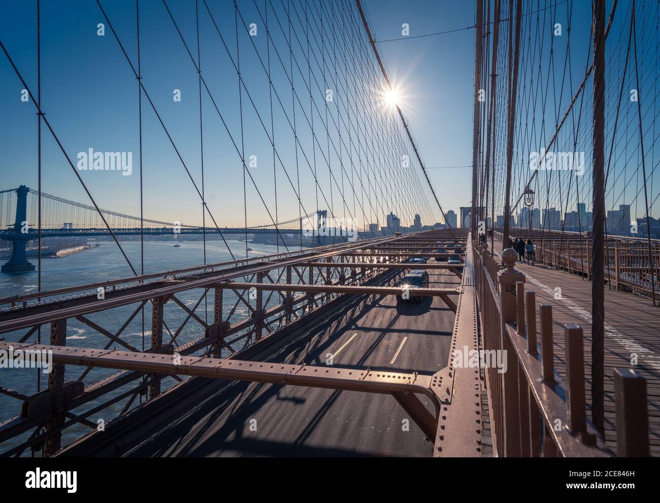 Cars driving on famous Brooklyn bridge over river in sunny afternoon in ...