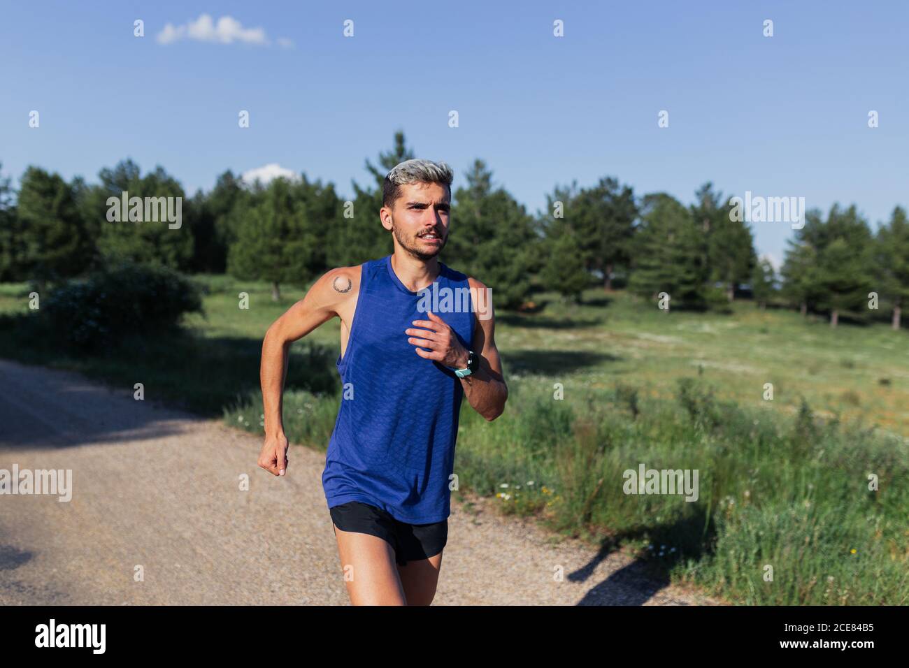 Determined man running on road during workout Stock Photo - Alamy