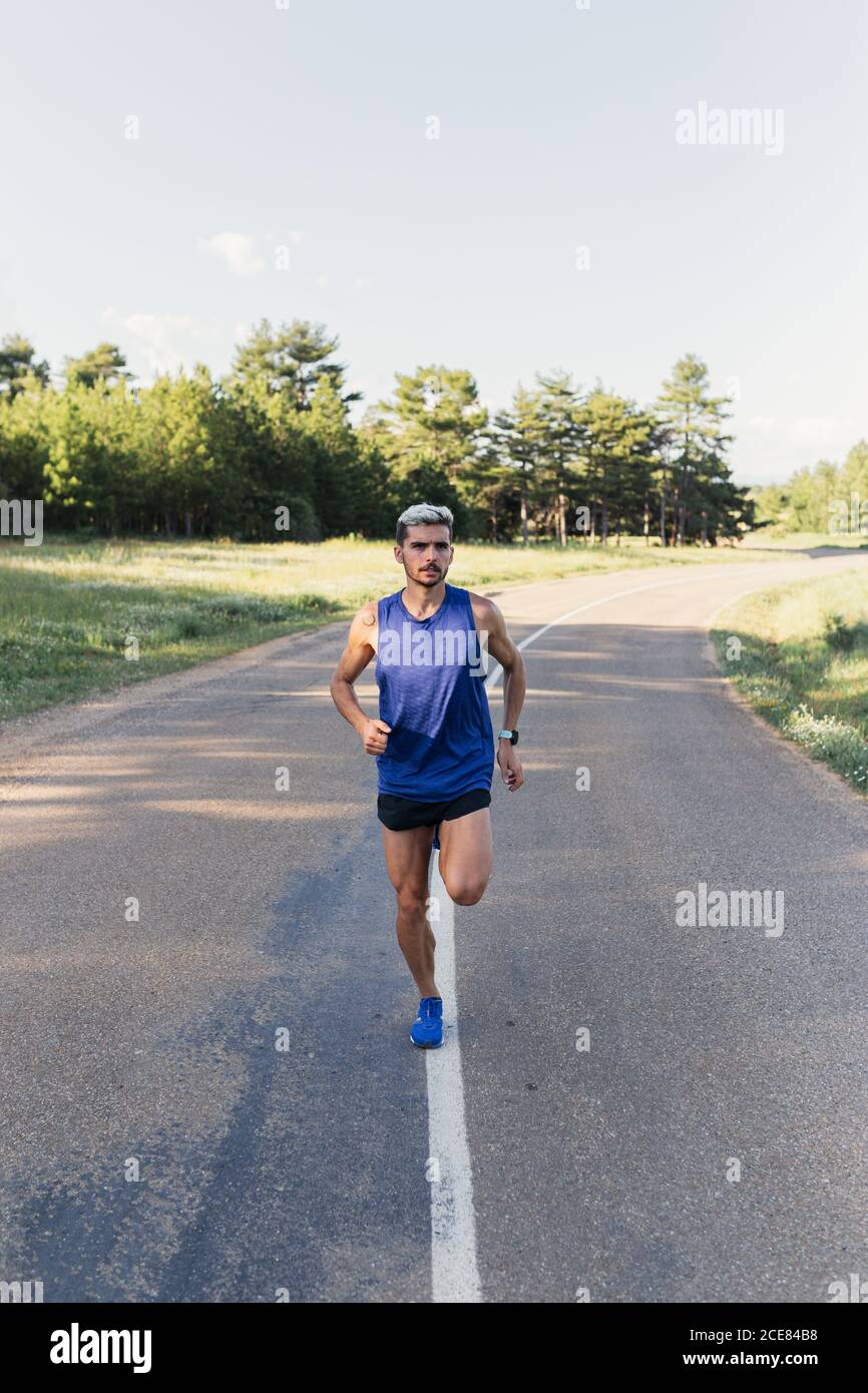 Determined man running on road during workout Stock Photo - Alamy